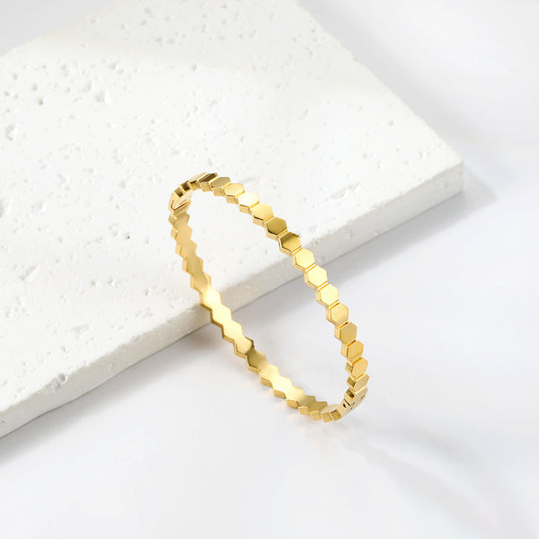 Hard bracelet with diamonds strung together with small gold-colored di